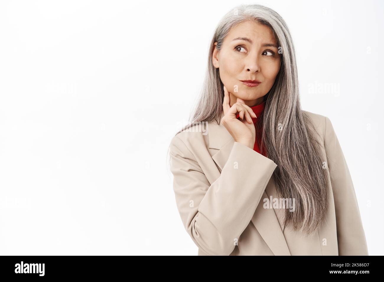 Portrait of asian corporate woman, middle aged lady thinking, looking ...