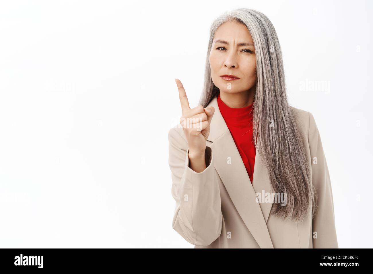 Portrait of serious asian middle-aged woman looking strict, shaking ...
