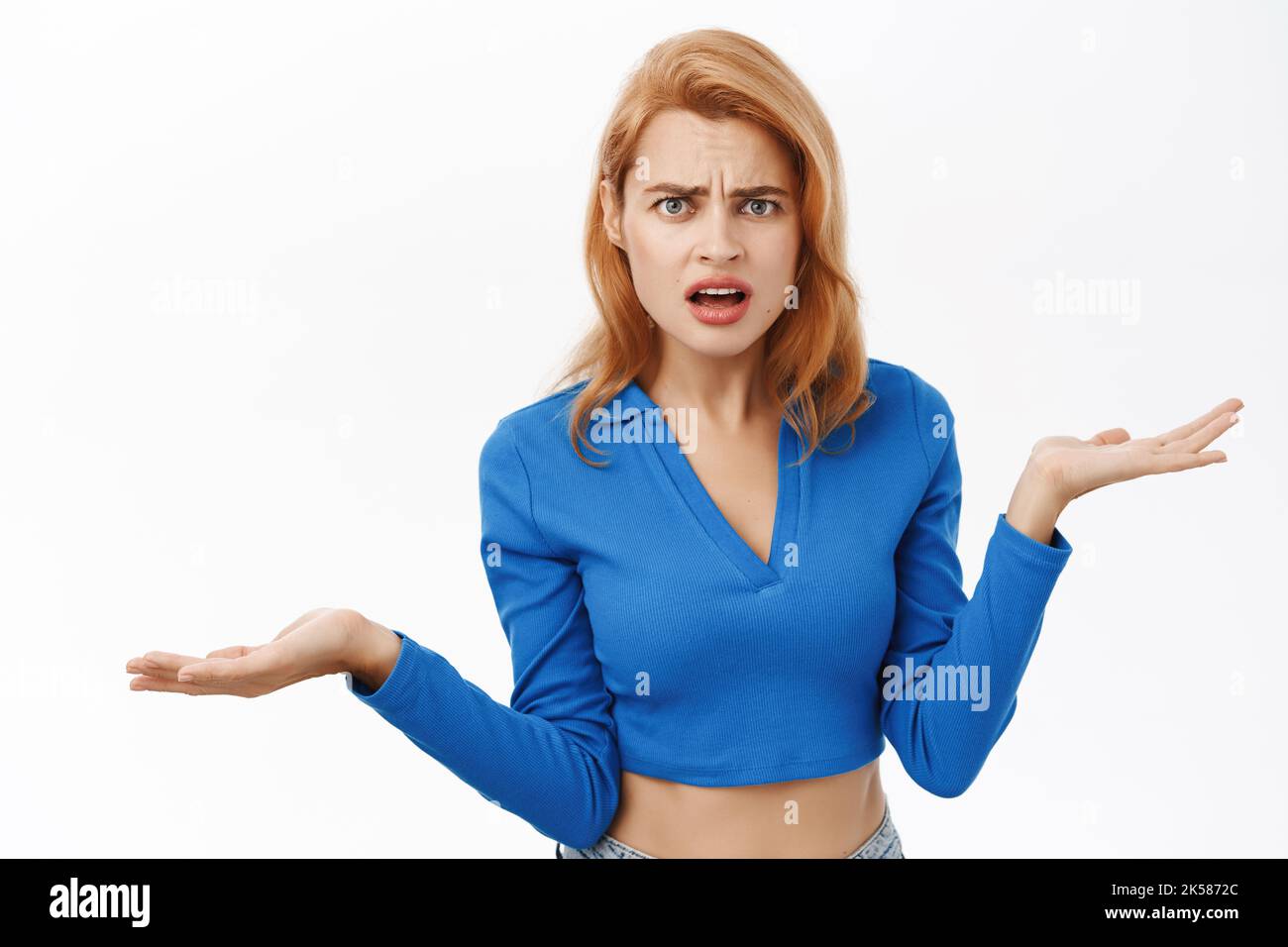 Whats wrong. Annoyed and confused woman shrugs shoulders, cant ...