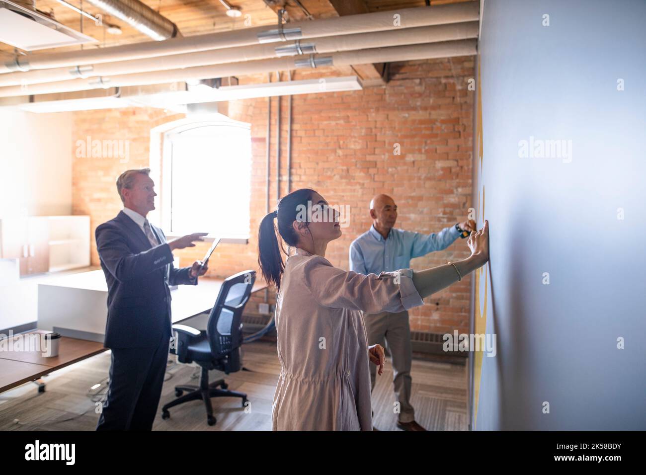 business people measuring wall in new office Stock Photo - Alamy