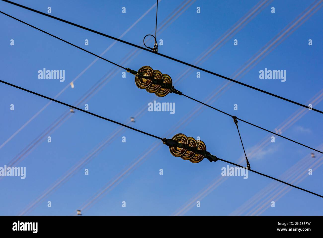 Close up of cables of overhead line for railroad with insulators and ...