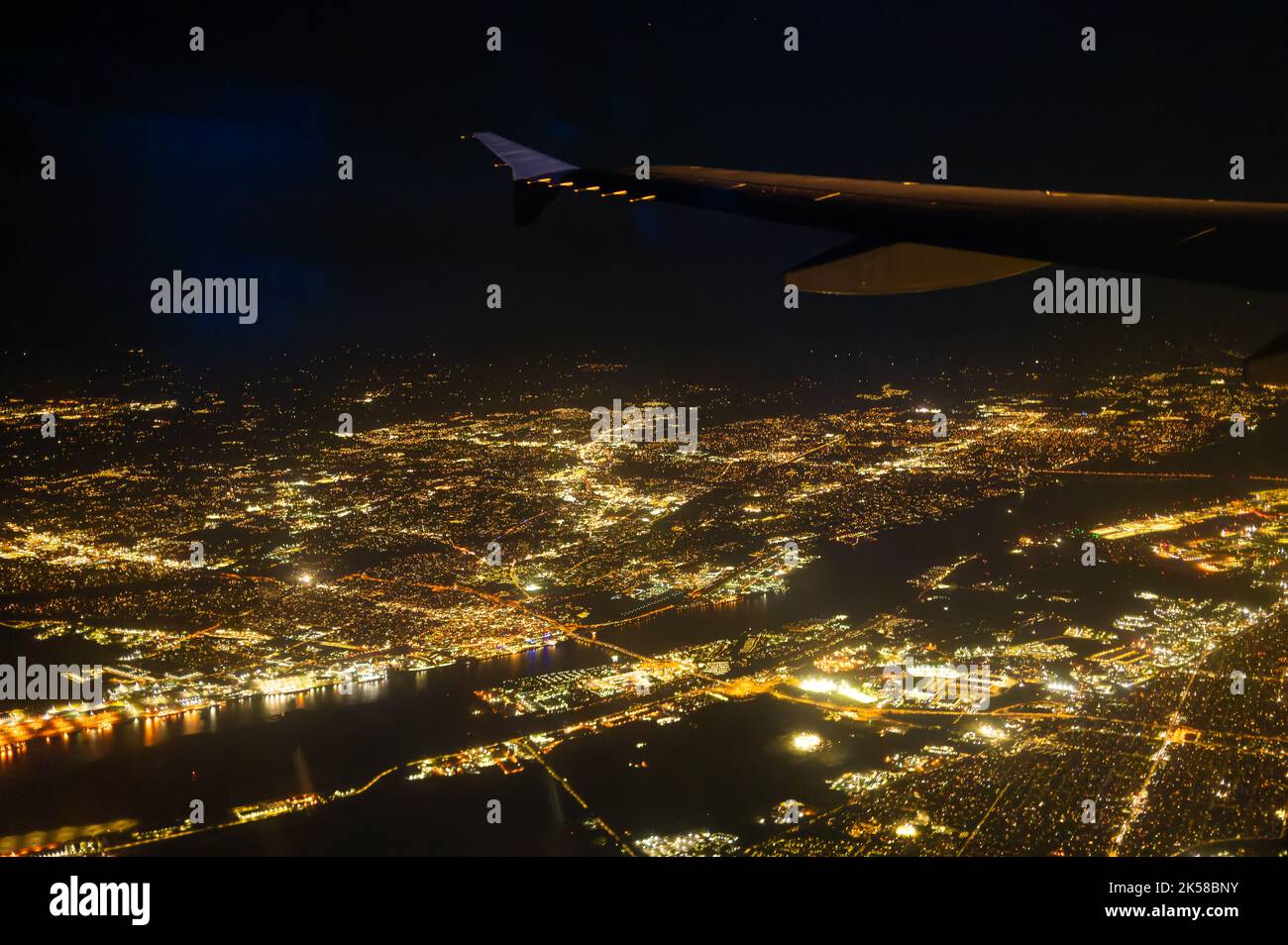 Shooting from the air. The plane in the sky flies over the night city ...
