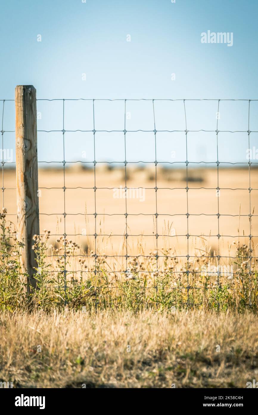 wire fence with farm fields behind it Stock Photo - Alamy