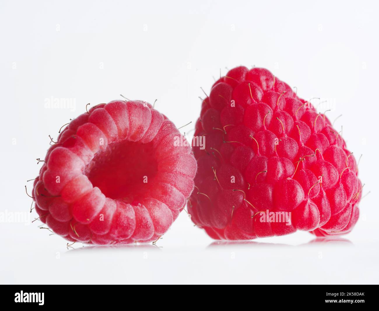 Two ripe red raspberries isolated on white background. Close-up. Sweet ...