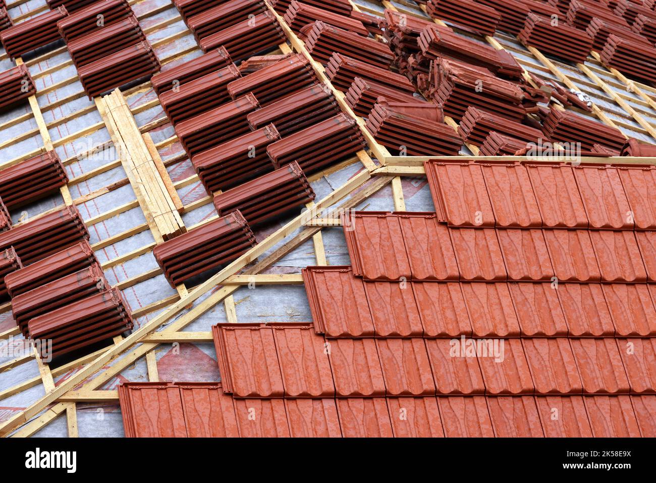 Roof building at new house construction. Brown roof tiles covering ...