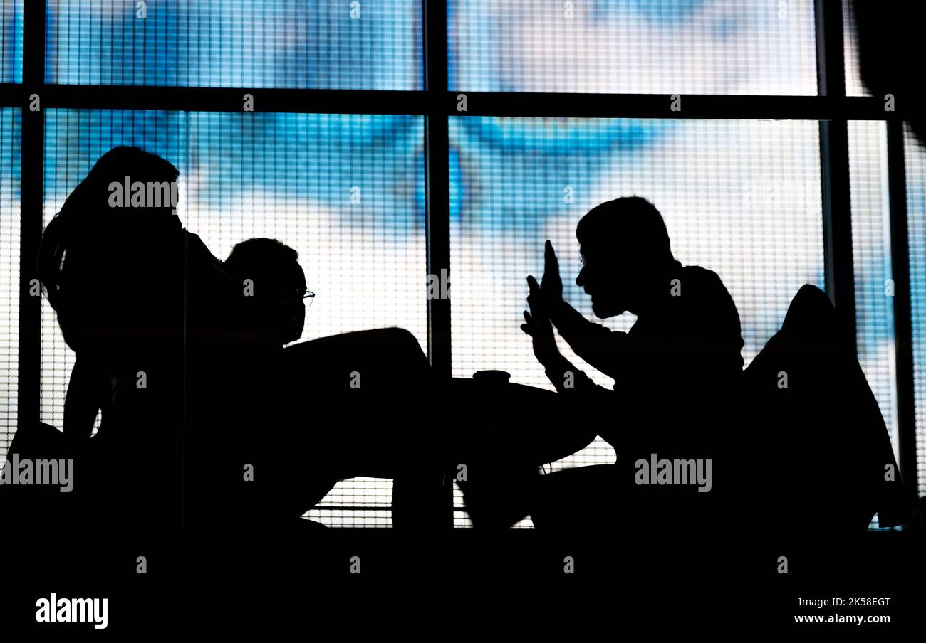 Boss speaking to employees at night Stock Photo - Alamy
