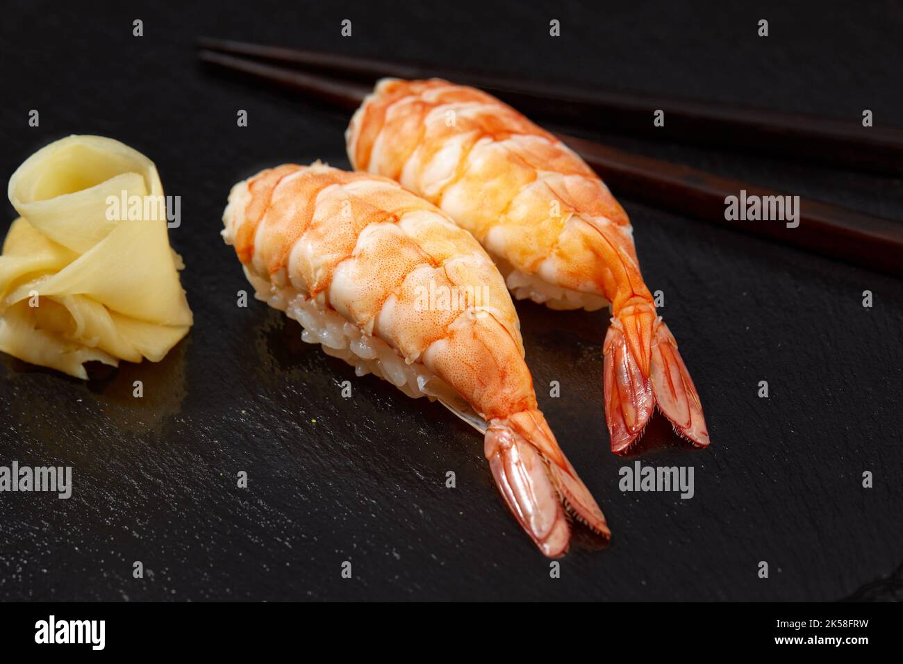 raw red shrimp nigiri photographed from above on black board, Japanese ...