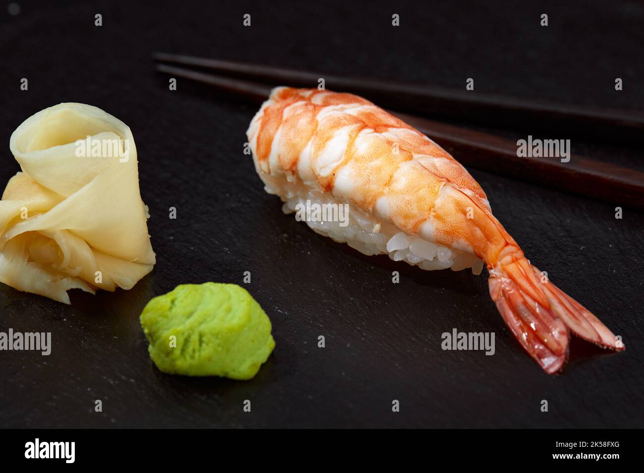 raw red shrimp nigiri photographed from above on black board, Japanese ...