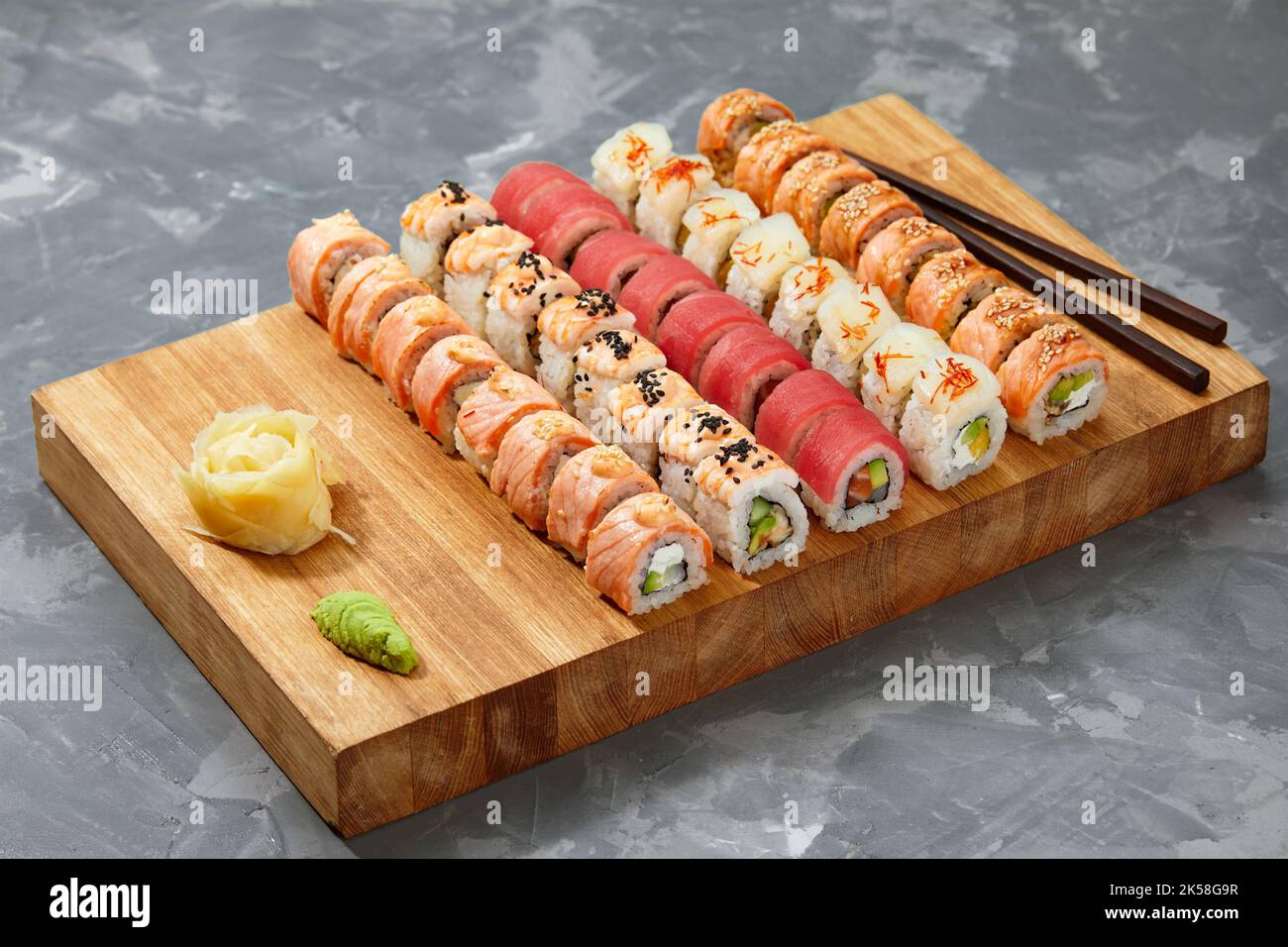 Different types of delicious and juicy sushi and rolls on a wooden ...