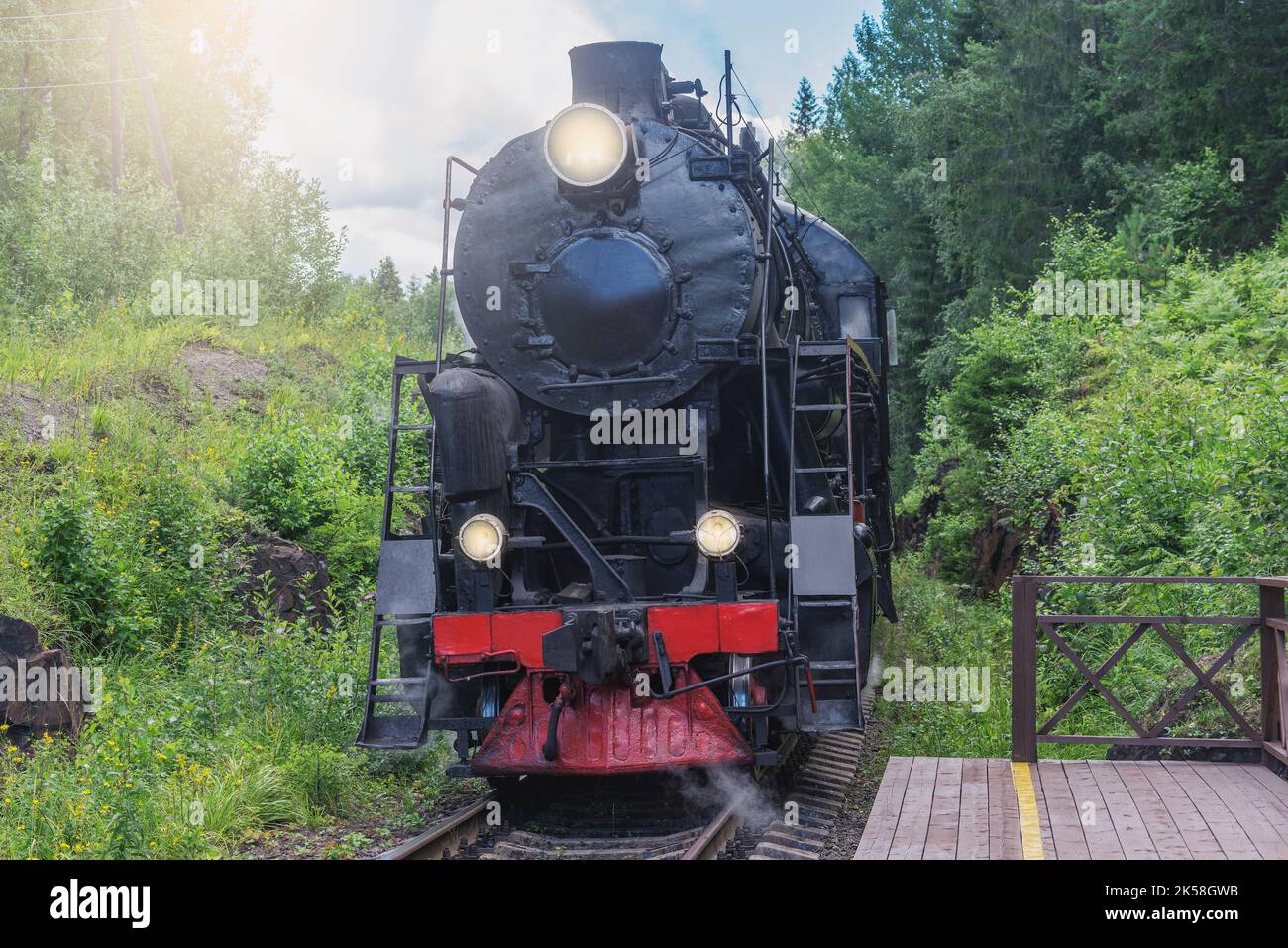 Retro steam train approaches to the platform at sunset Stock Photo - Alamy