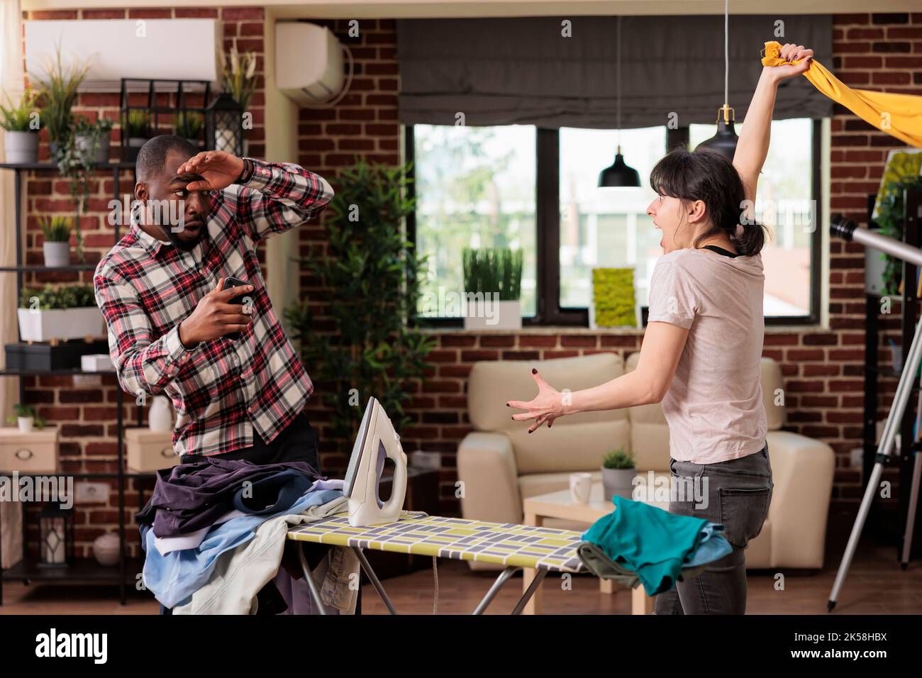 Nervous upset woman trying to hit husband while having a big fight at ...