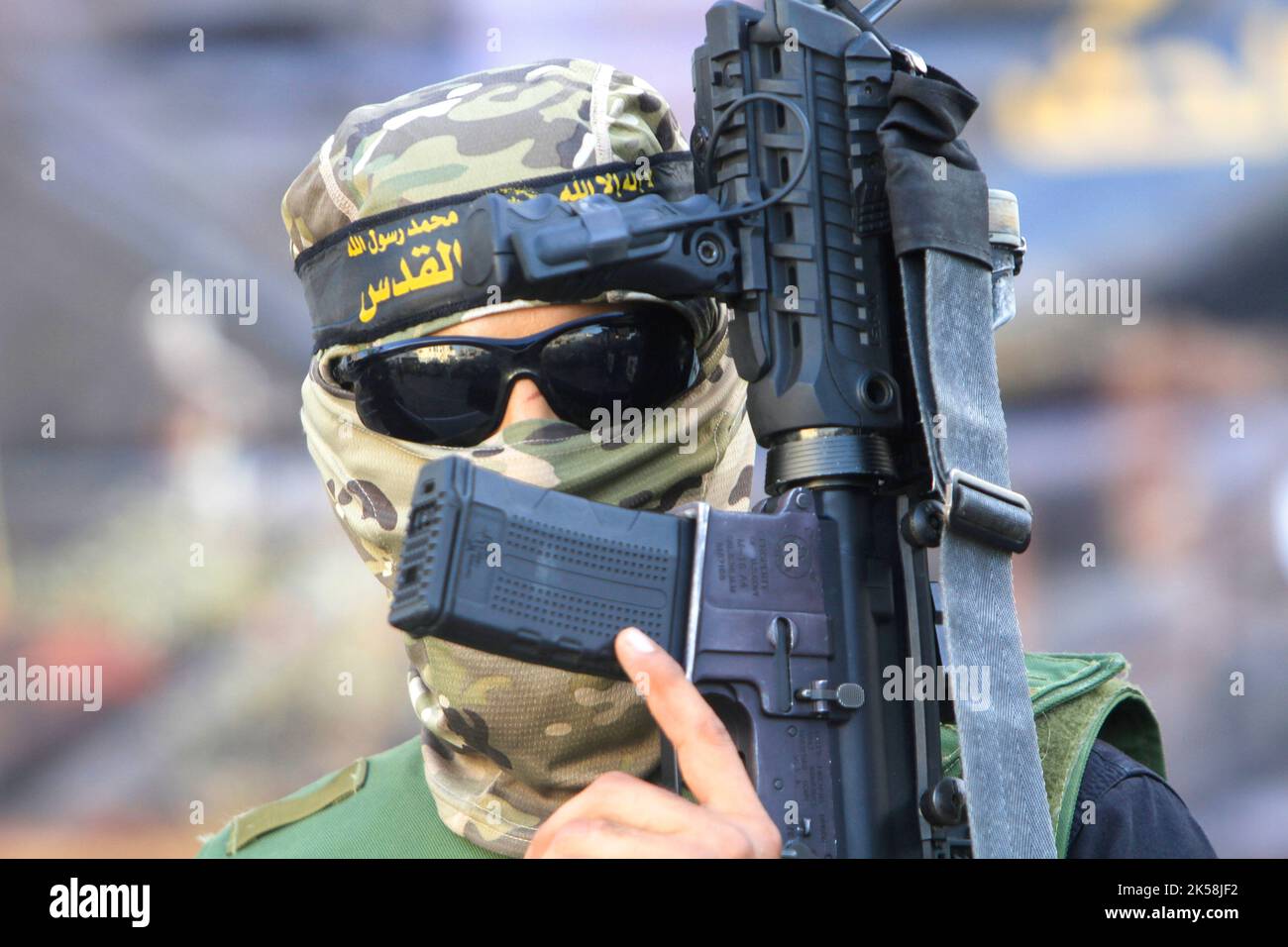 Palestinian gunman from the Islamic Jihad movement carries his weapon ...