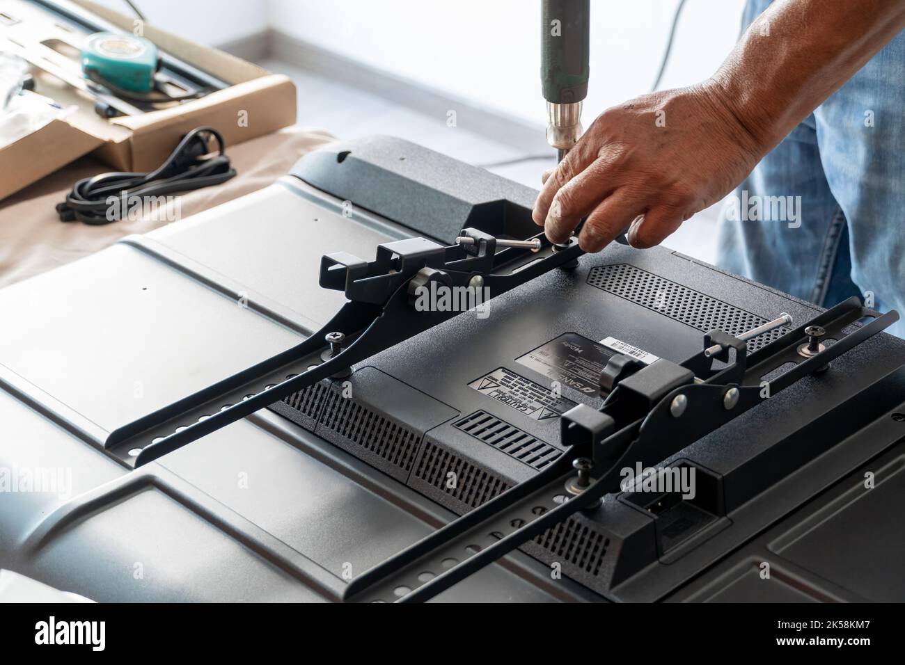 man installing the wall base for the television, it is a smart tv ...