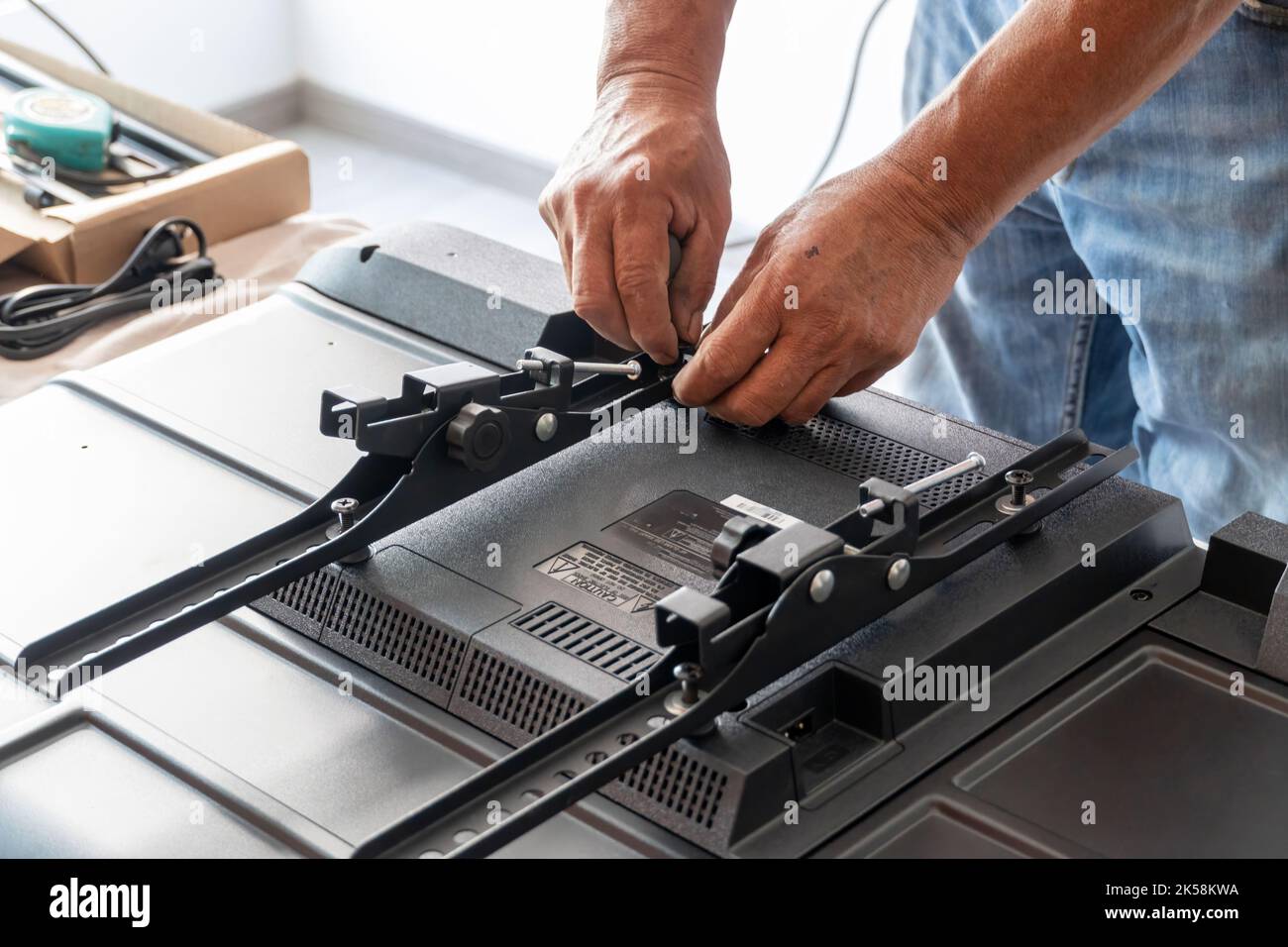 man installing the wall base for the television, it is a smart tv ...