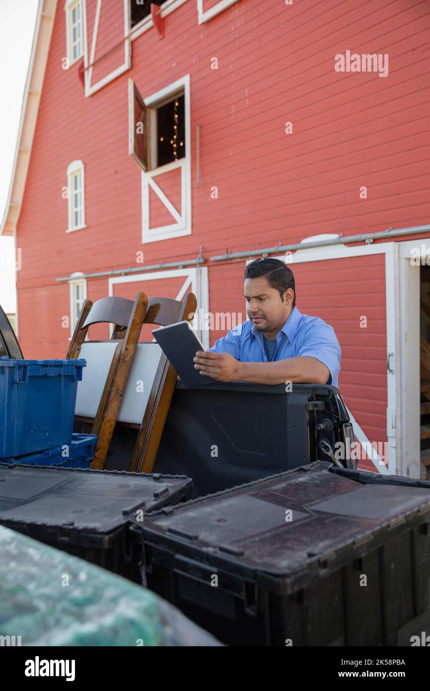 Event delivery man with digital tablet at truck outside barn Stock ...