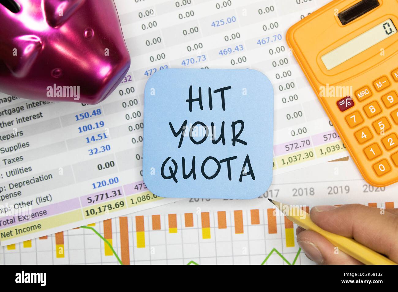 Closeup on businessman holding a card with text HIT YOUR QUOTA ...