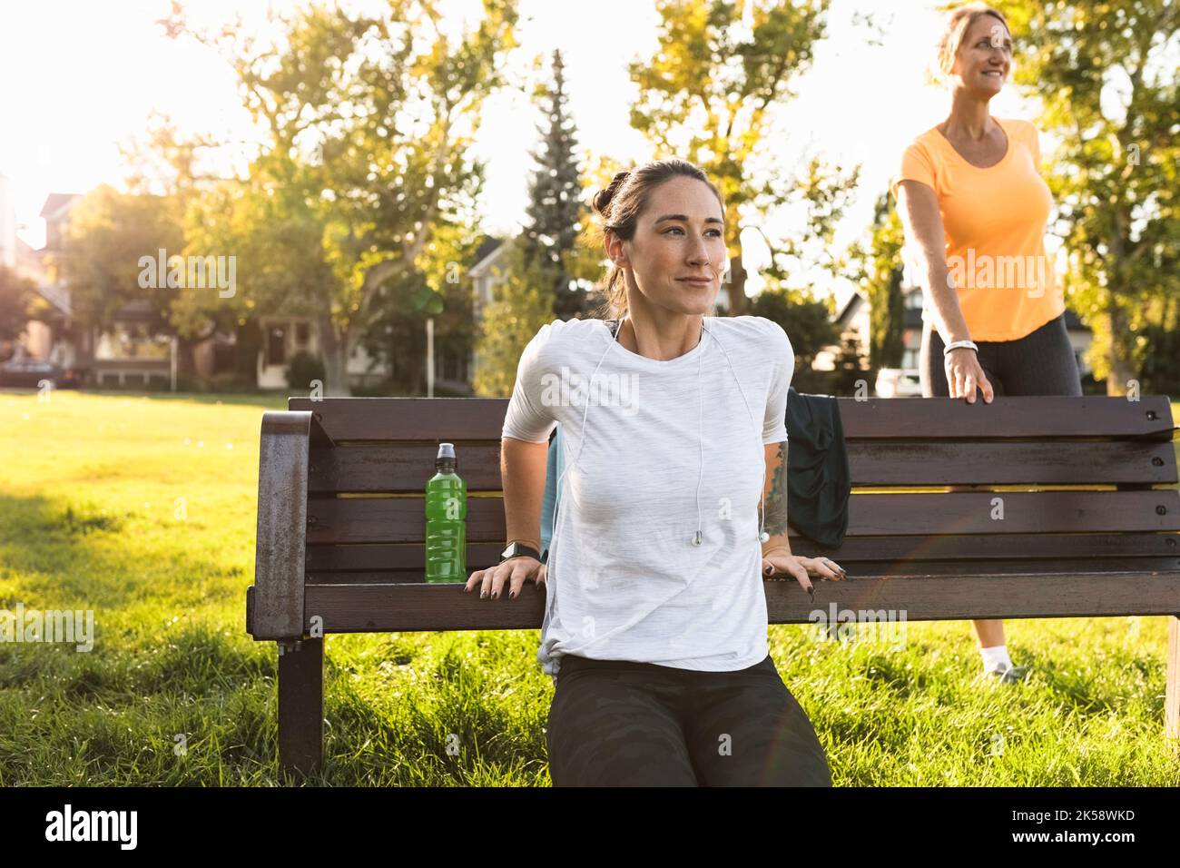 Woman stretching on park bench after a run Stock Photo - Alamy
