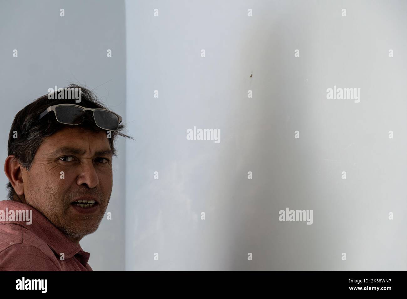 latin man repairing wall, white wall background, latin america Stock ...