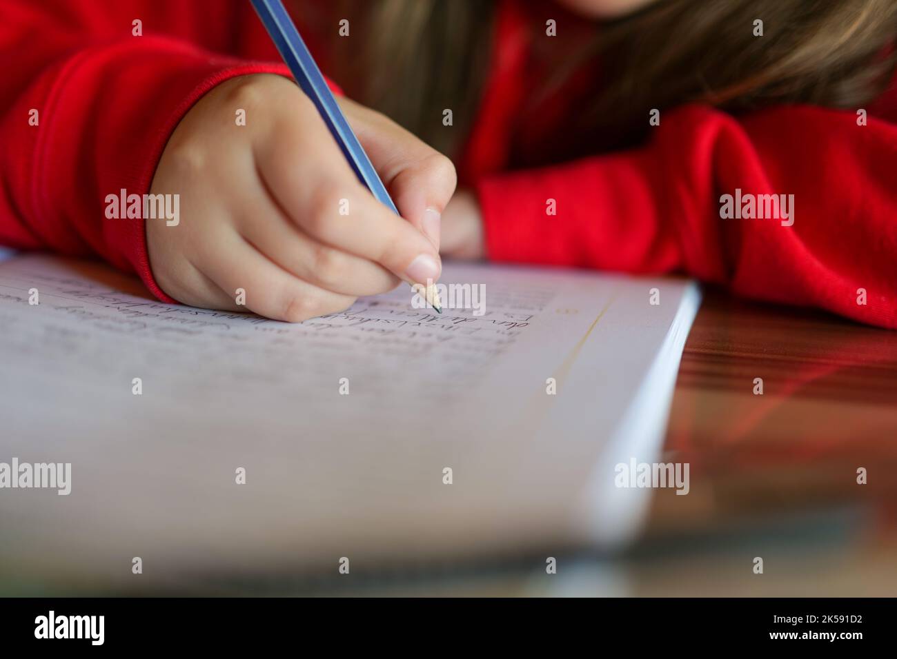 Homework.girl does her homework.pencil in a childs hand writes words in ...