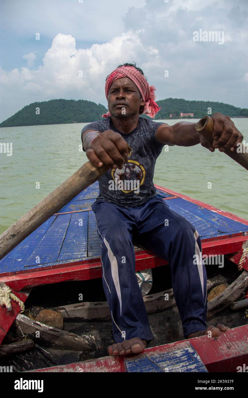 a poor tribal man pulling boat by his hand with paddle Stock Photo - Alamy
