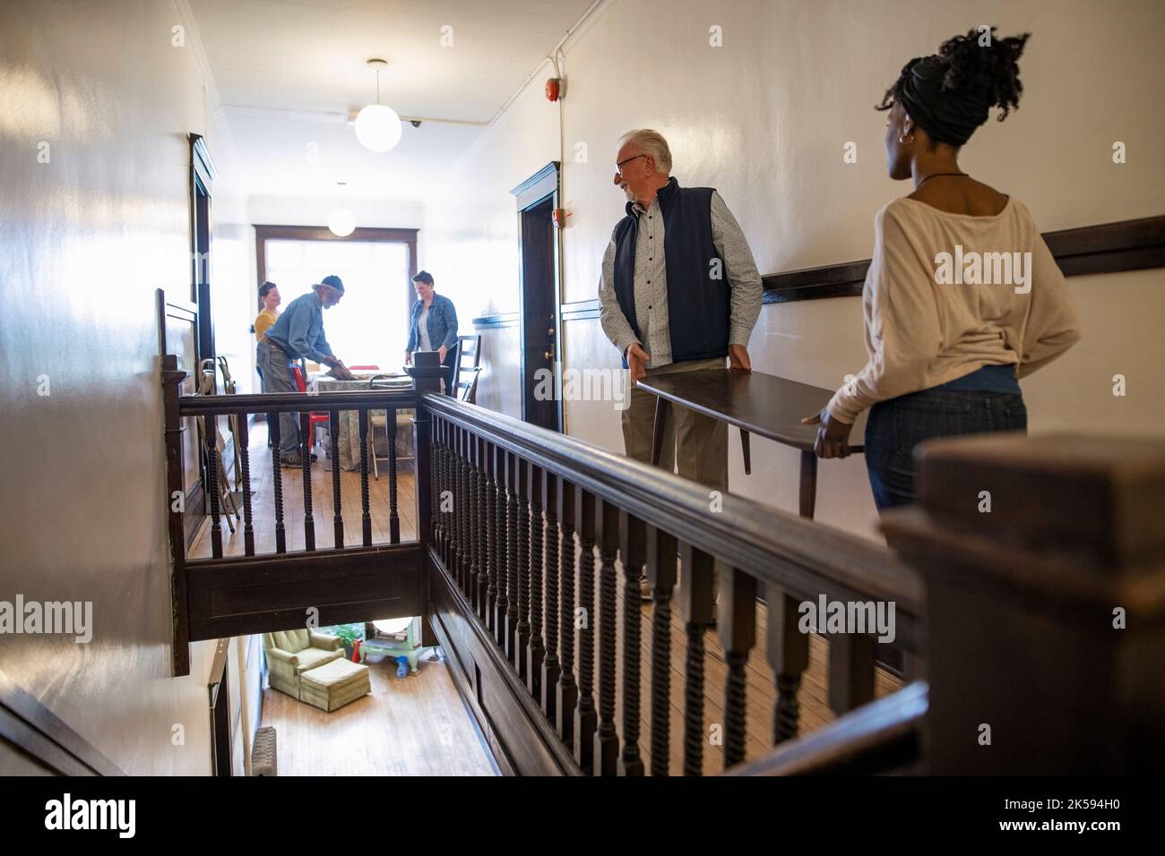 Neighbors moving tables for community dinner in apartment hallway Stock ...