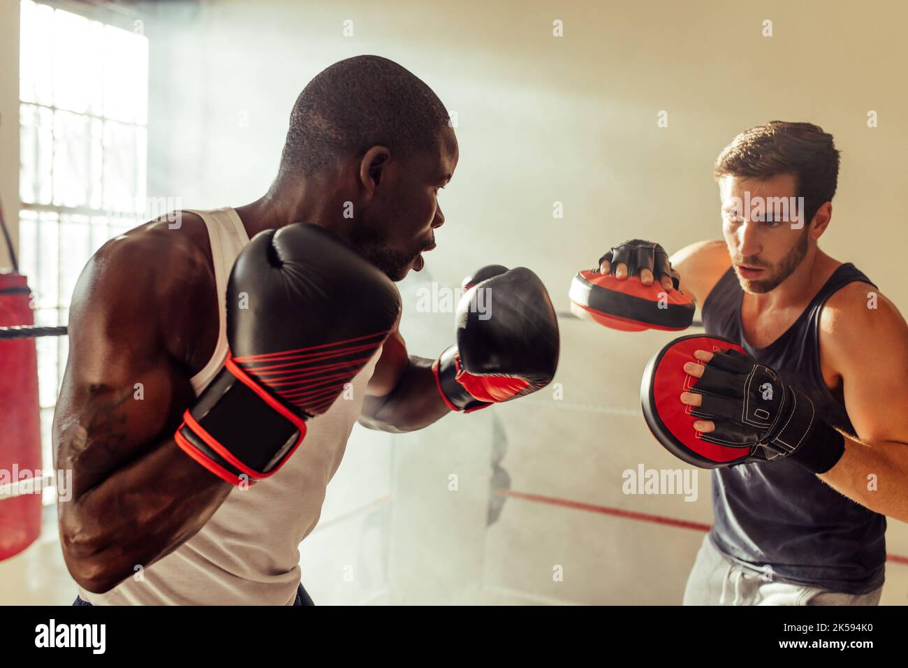 Athletic young man working on punching combinations with the focus ...