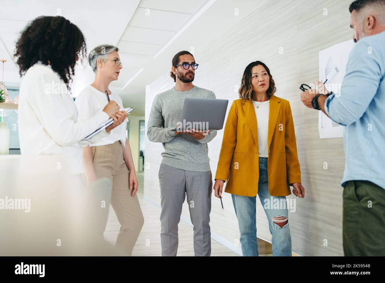 Group of diverse design professionals sharing ideas during a meeting in a modern office. Team of ...