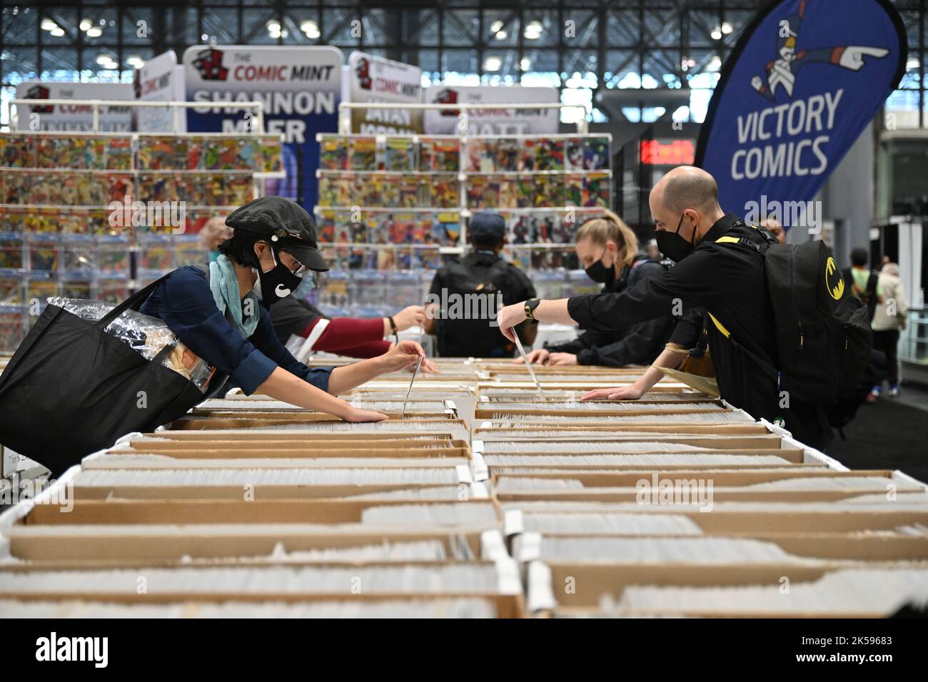 People look through boxes of comic books at New York Comic Con at the ...