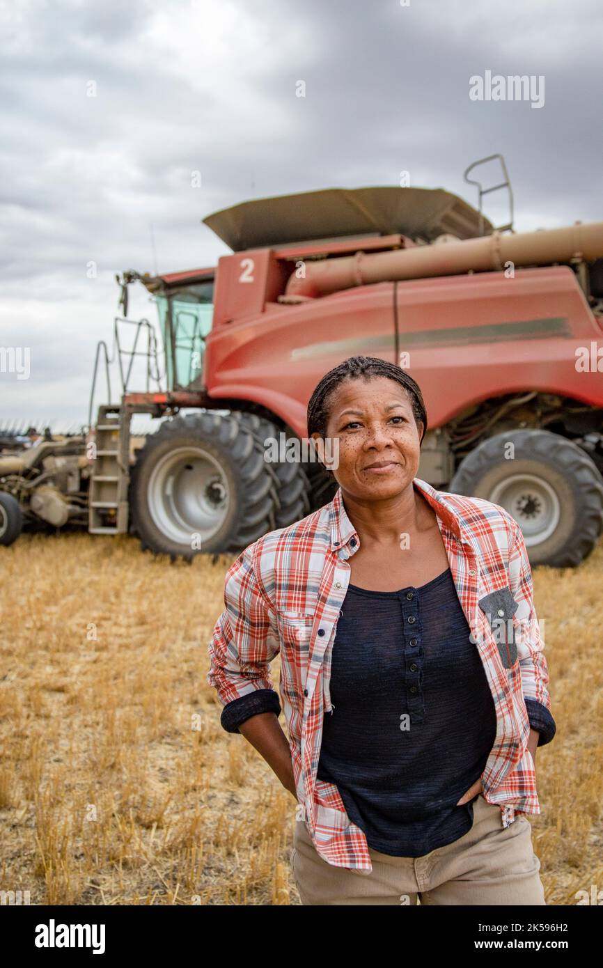 Portrait confident female farmer standing outside combine harvester ... Portrait confident female farmer standing outside combine harvester ...