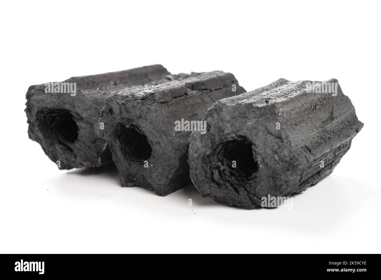 three pieces of charcoal on a white background Stock Photo - Alamy