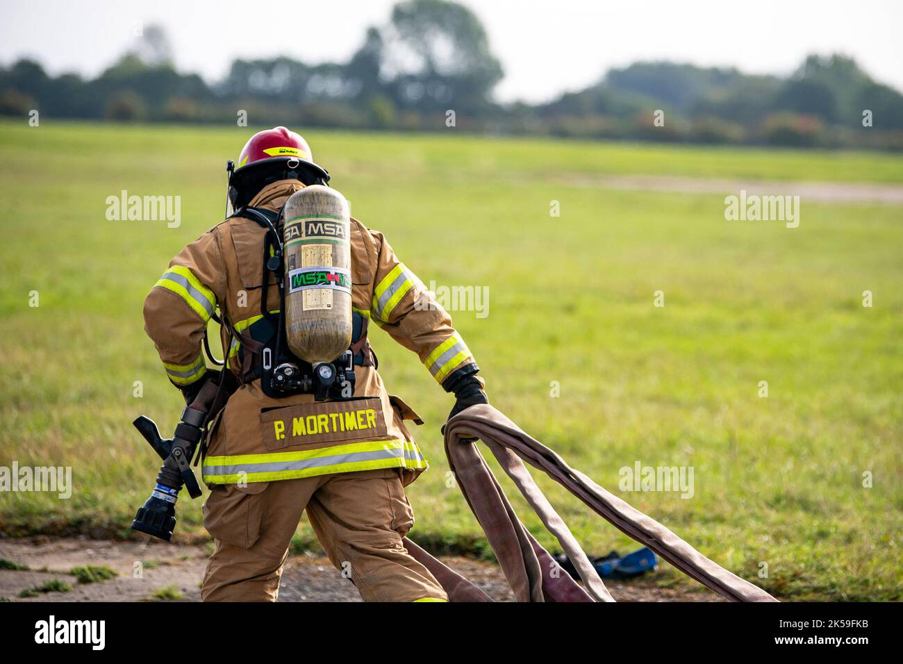A firefighter from the 422d Fire Emergency Services, pulls a fire hose ...