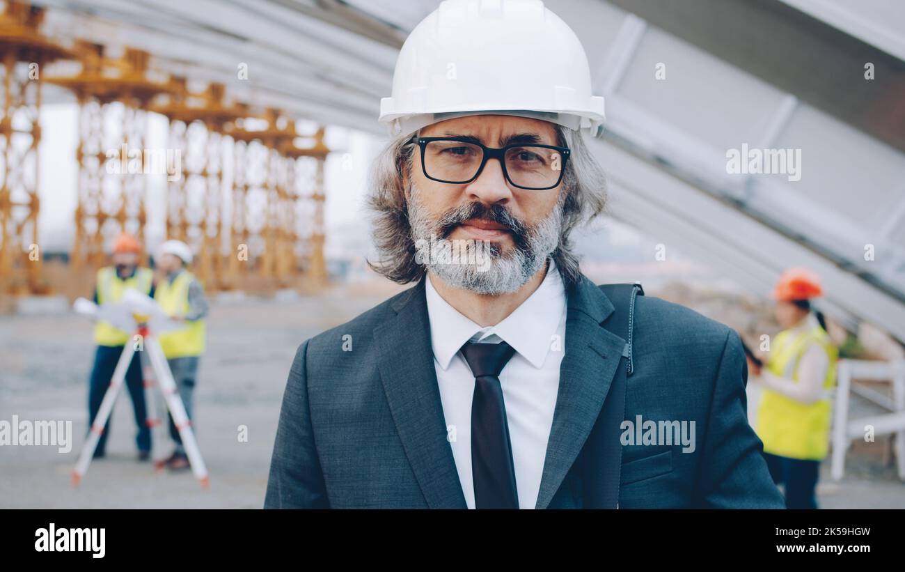 Portrait of serious mature man investor standing outdoors in ...