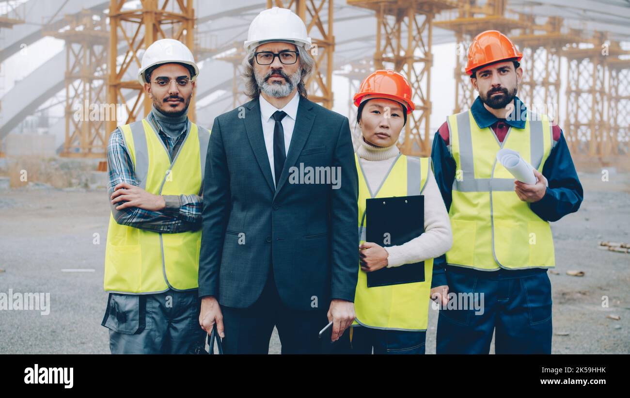 Multi-ethnic group of people builders standing outdoors in industrial ...