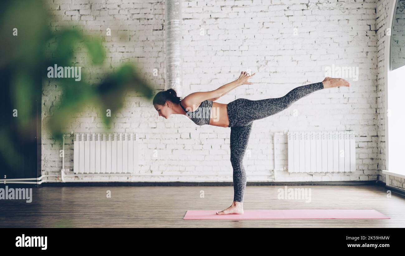 Experienced female yoga teacher is practicing standing half forward ...