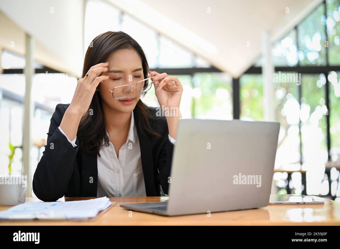 Exhausted millennial Asian businesswoman or female office worker taking ...
