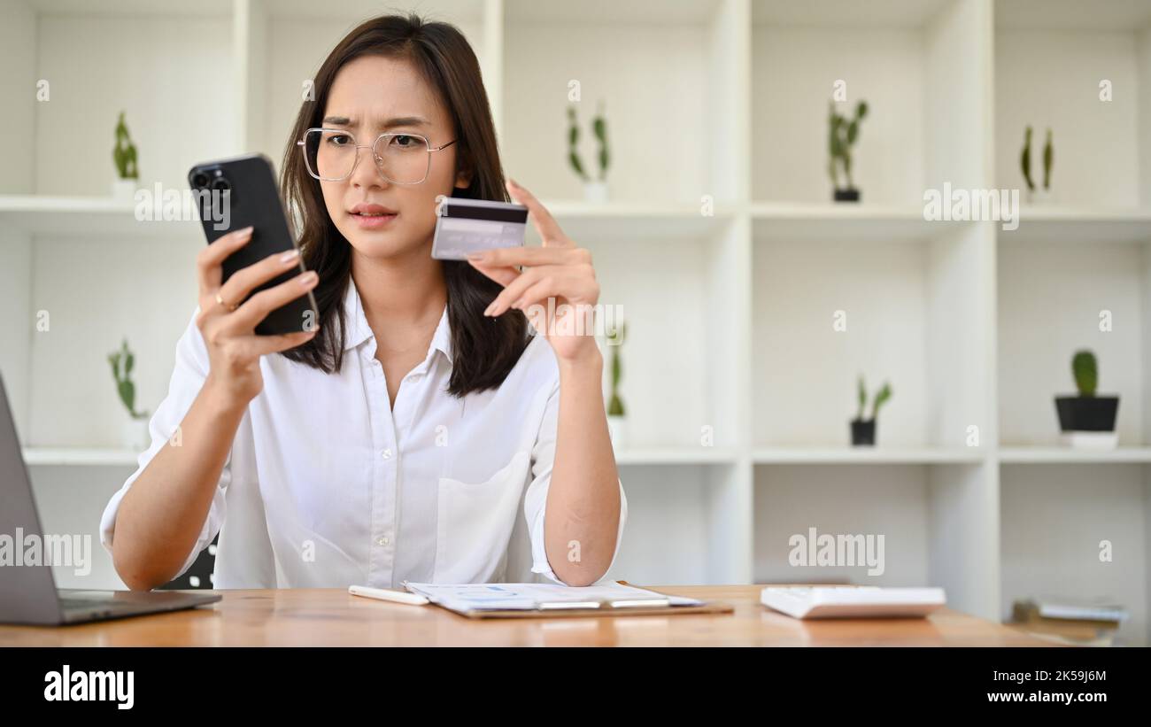 Attractive millennial Asian woman having a problems on her mobile ...