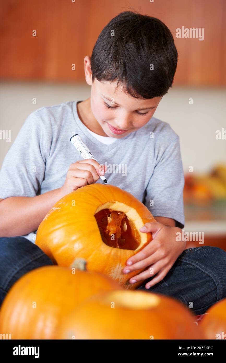 My Jack-O-Lantern is going to be the best. A little boy sitting in the ...
