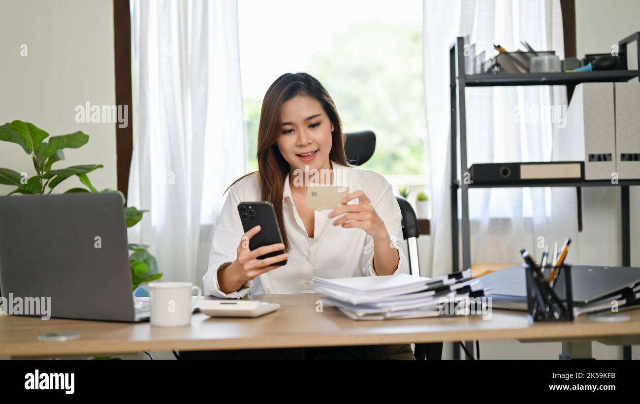 Gorgeous young Asian businesswoman or female CEO sitting at her desk ...