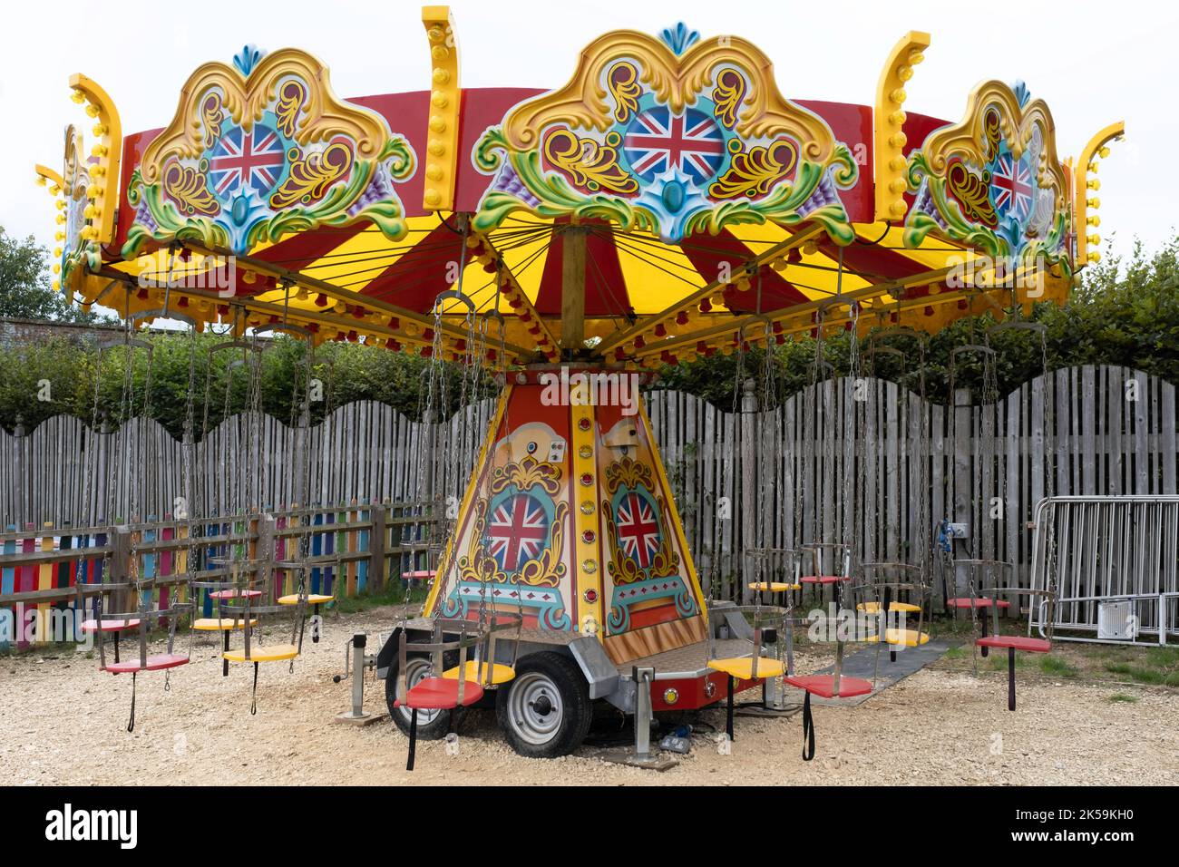 Empty mobile colorful merry-go-round with chairs hanging from a chain ...