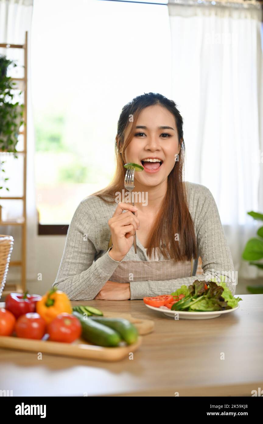 Portrait Attractive And Happy Young Asian Woman Enjoys Eating Her Homemade Salad At Her Dining