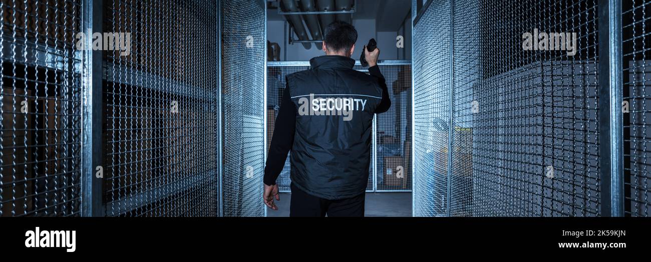 Security Guard With Flashlight At Night In Warehouse Stock Photo - Alamy