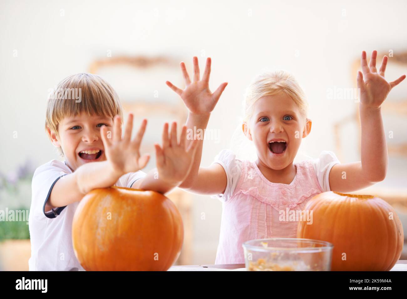 They love pumpkin carving. Portrait of a little boy and girl looking ...