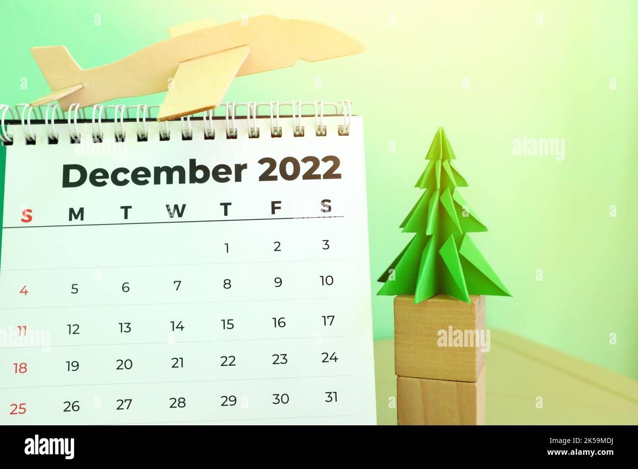 Selective focus of December 2022 desk calendar with airplane model and ...