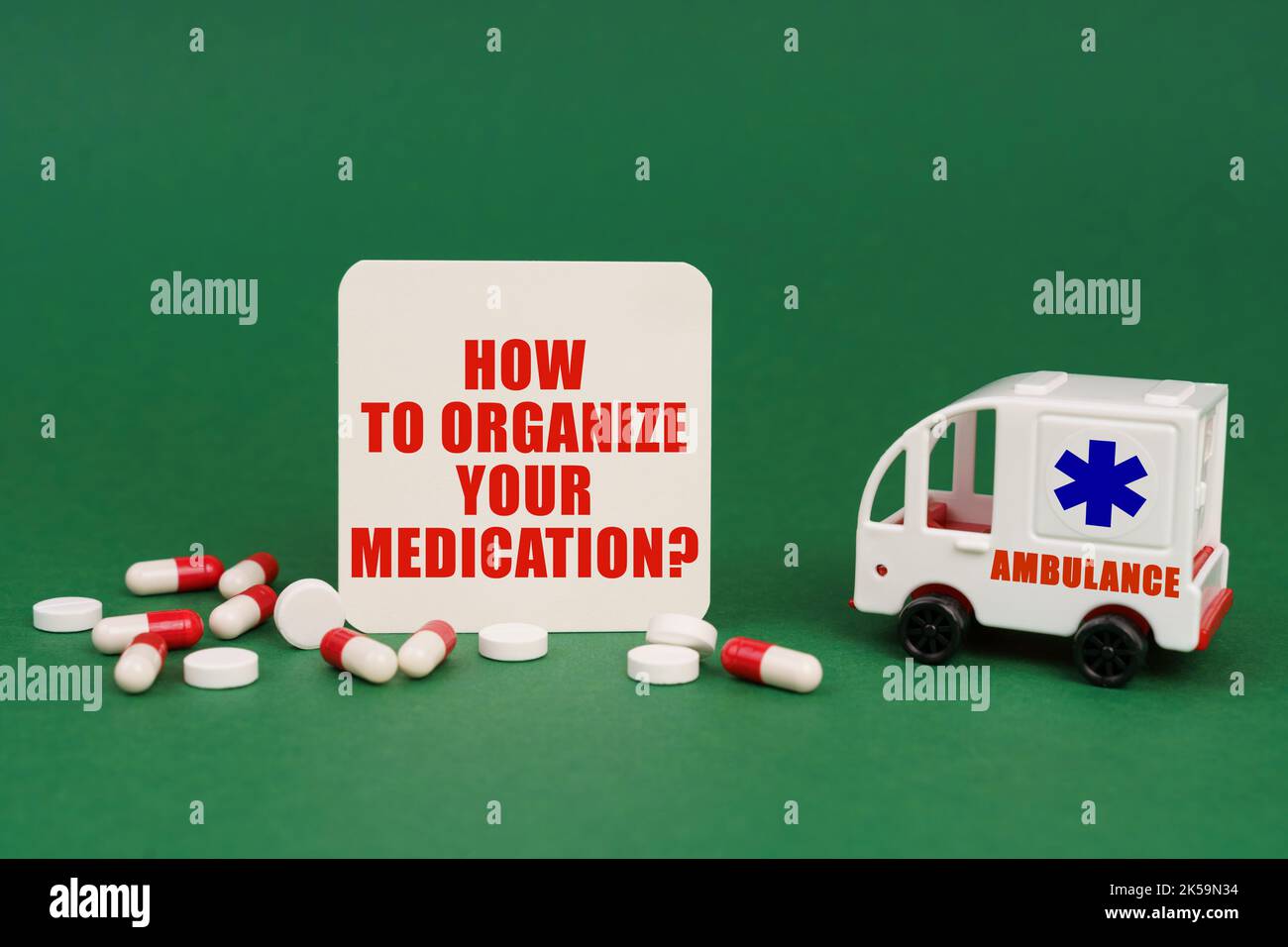Medical concept. On a green surface, an ambulance, pills and a sign ...