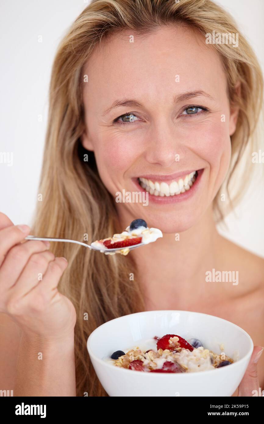 Eating healthily keeps her young. Beautiful woman smiling happily while ...