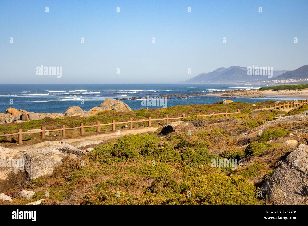 Walkway with fence along Atlantic Ocean coast with mountain on ...