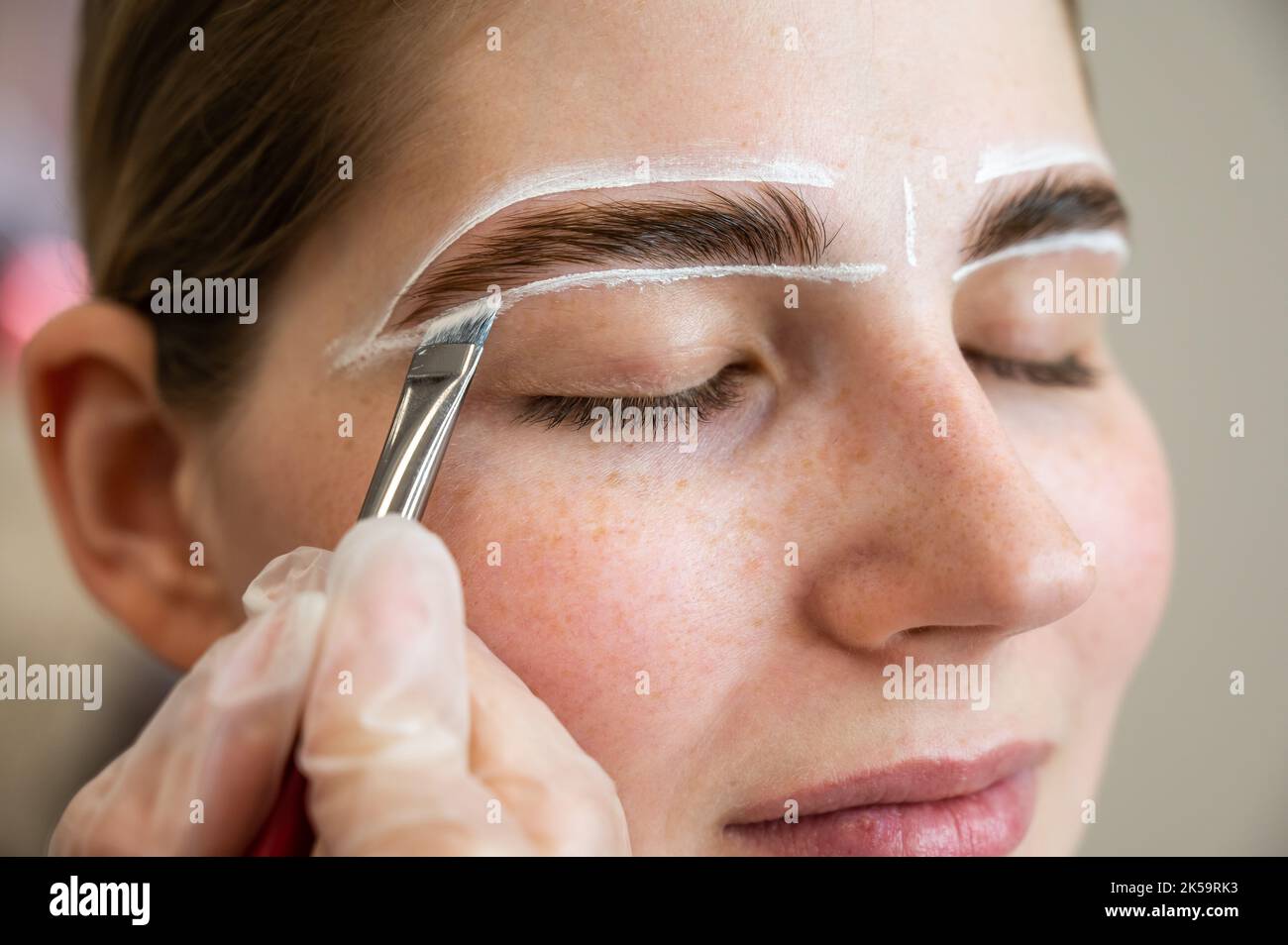 The master draws the shape of the eyebrows with white paint before ...