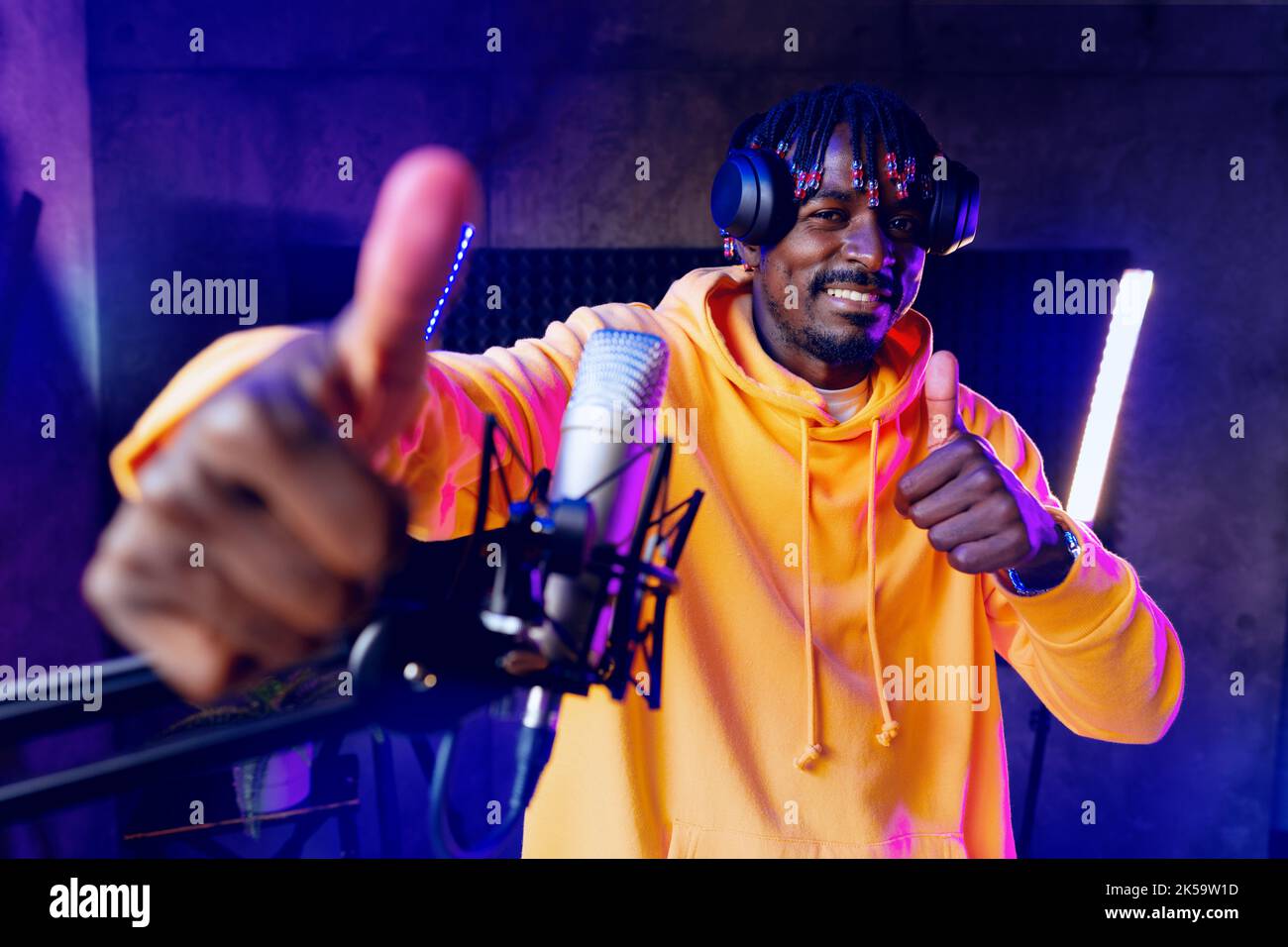 Young African performer recording his new track in recording studio ...