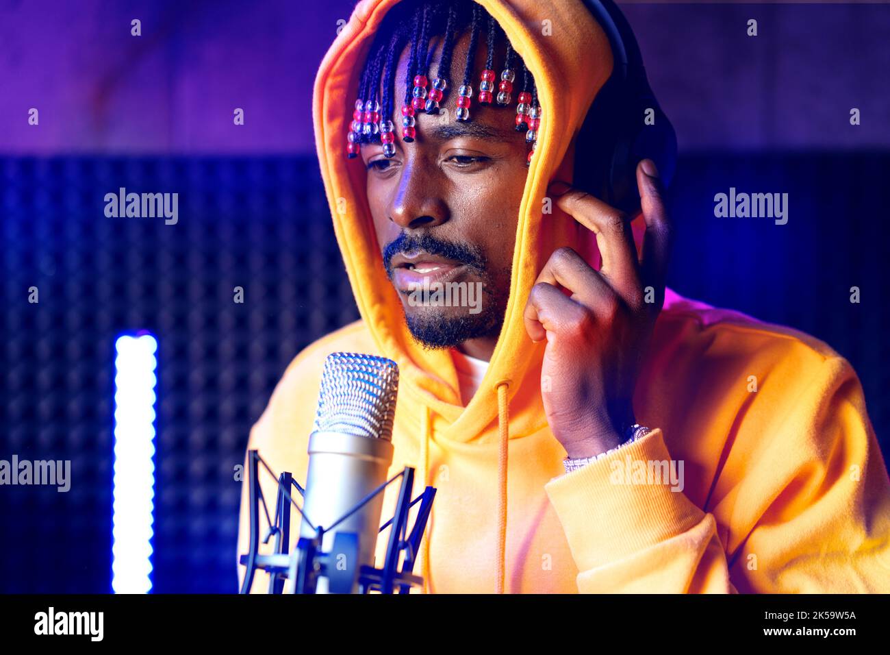 Young African performer recording his new track in recording studio ...