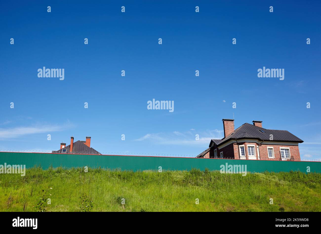 Facade of a European suburban buildings. Metal fence and house against ...